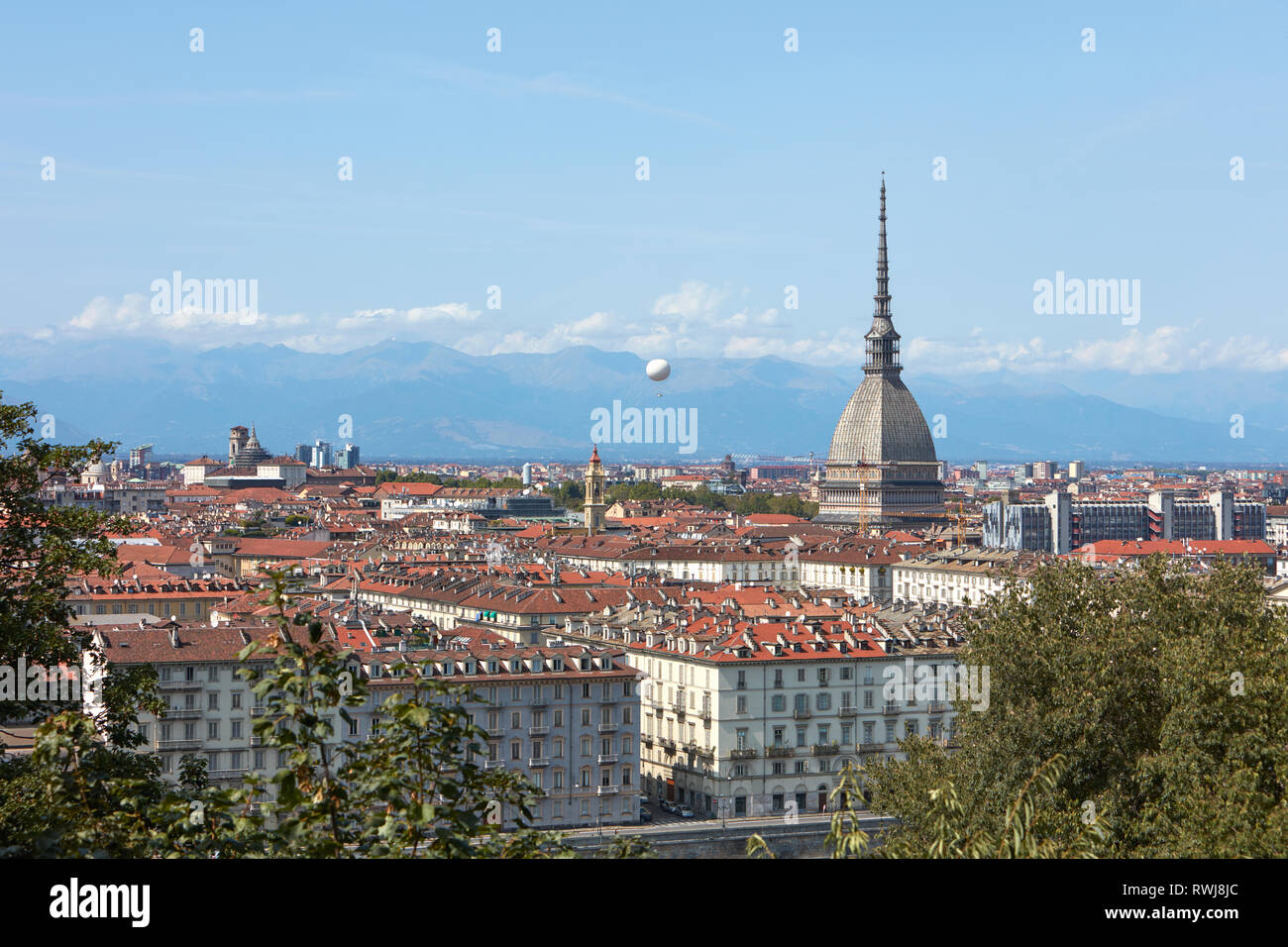 Turin rooftops view, Mole Antonelliana tower and hot air balloon in a ...