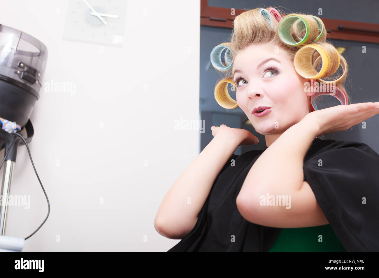 Portrait of funny happy woman in beauty salon. Cheerful blond girl with ...