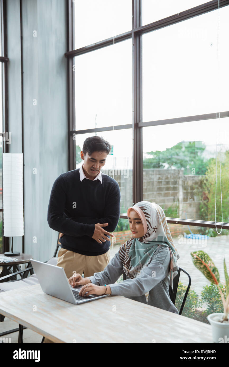 the owner give a briefing to a new employee about operate the computer ...
