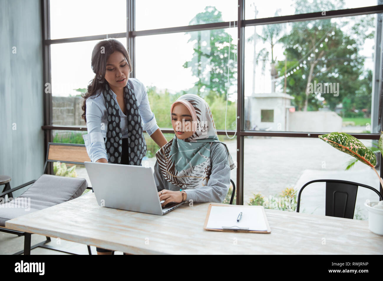 veiled asian women employees find a problem and her boss helping Stock ...