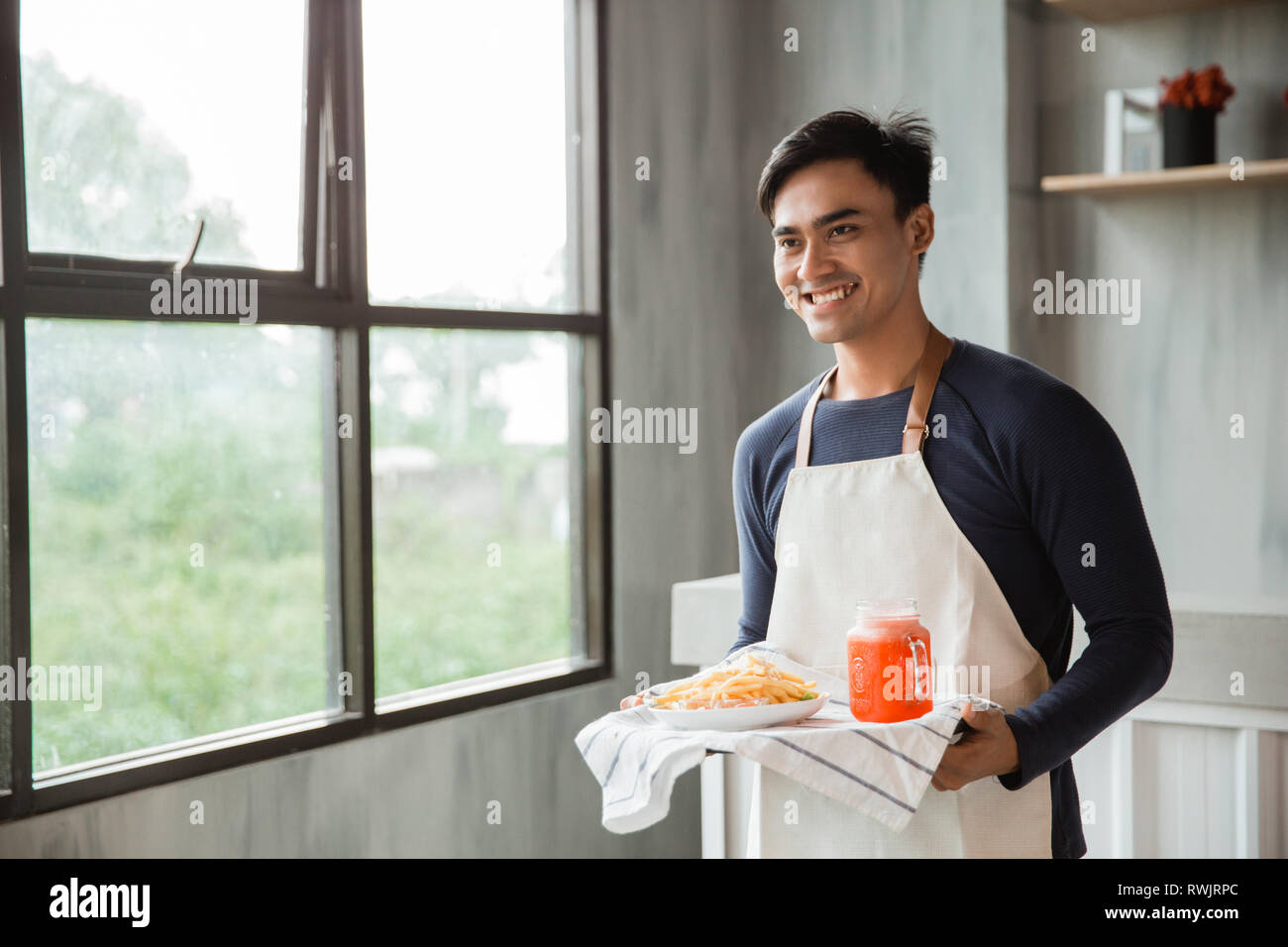 handsome asian waiters wearing apron serving meal and beverage with ...