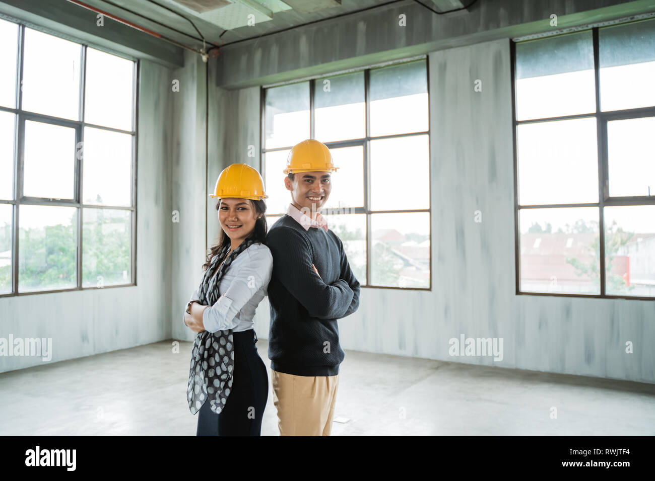 engineer team back to back folded hands standing in the hall wearing a ...