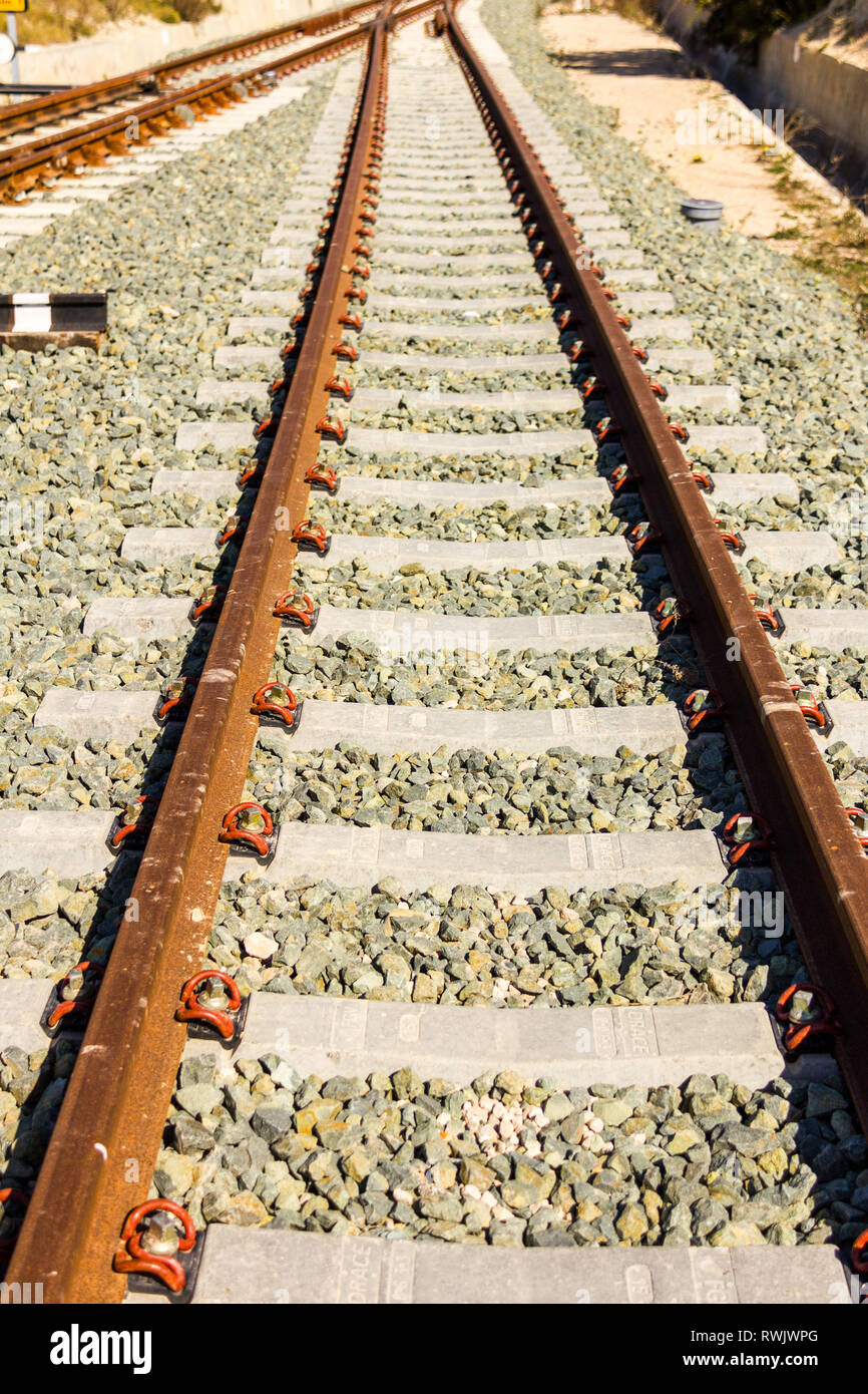 A railroad switch track with traffic signs, mountains and trees in the ...