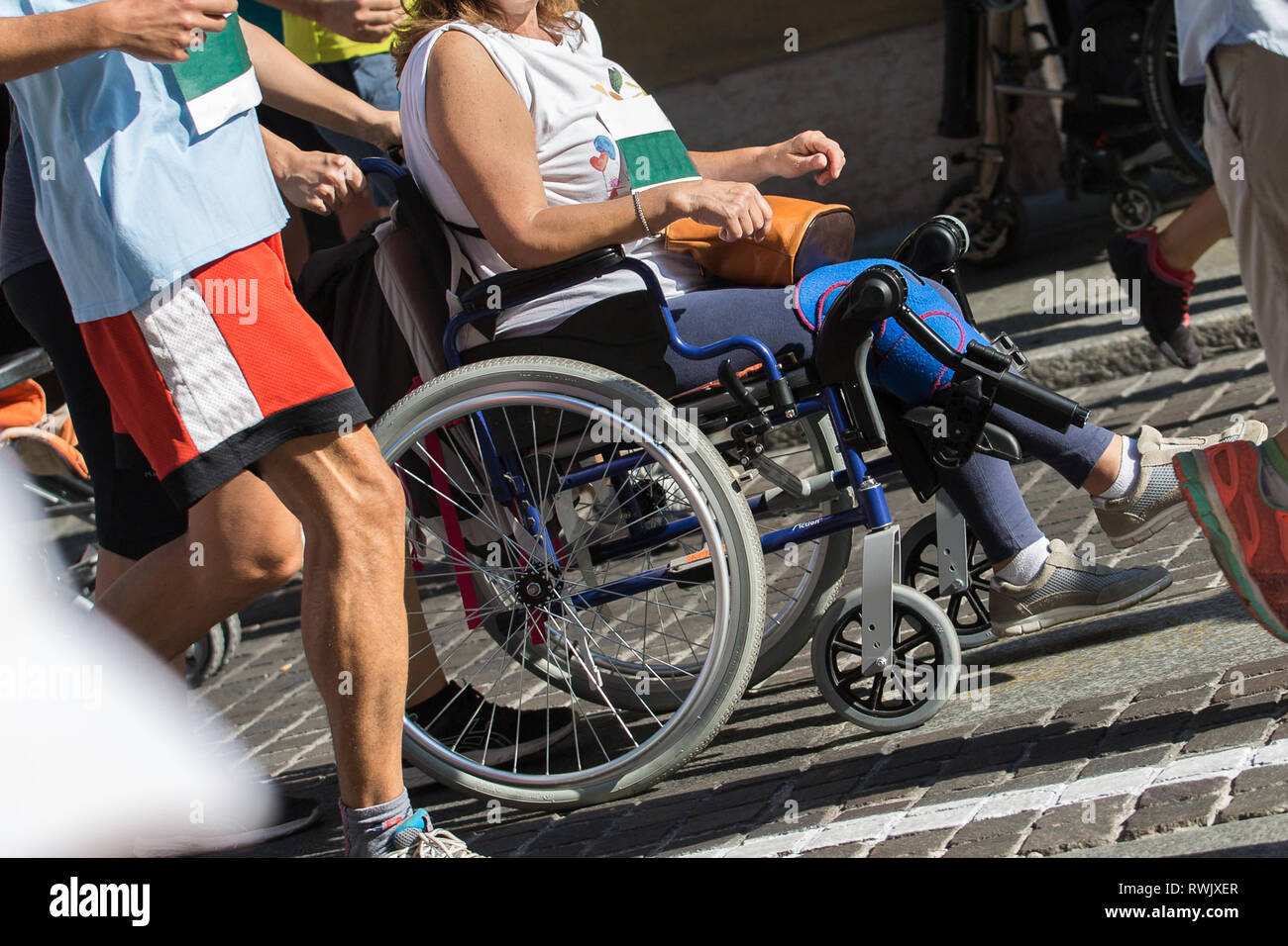 Disabled Athlete in a Sport Wheelchair during Marathon Helped by ...