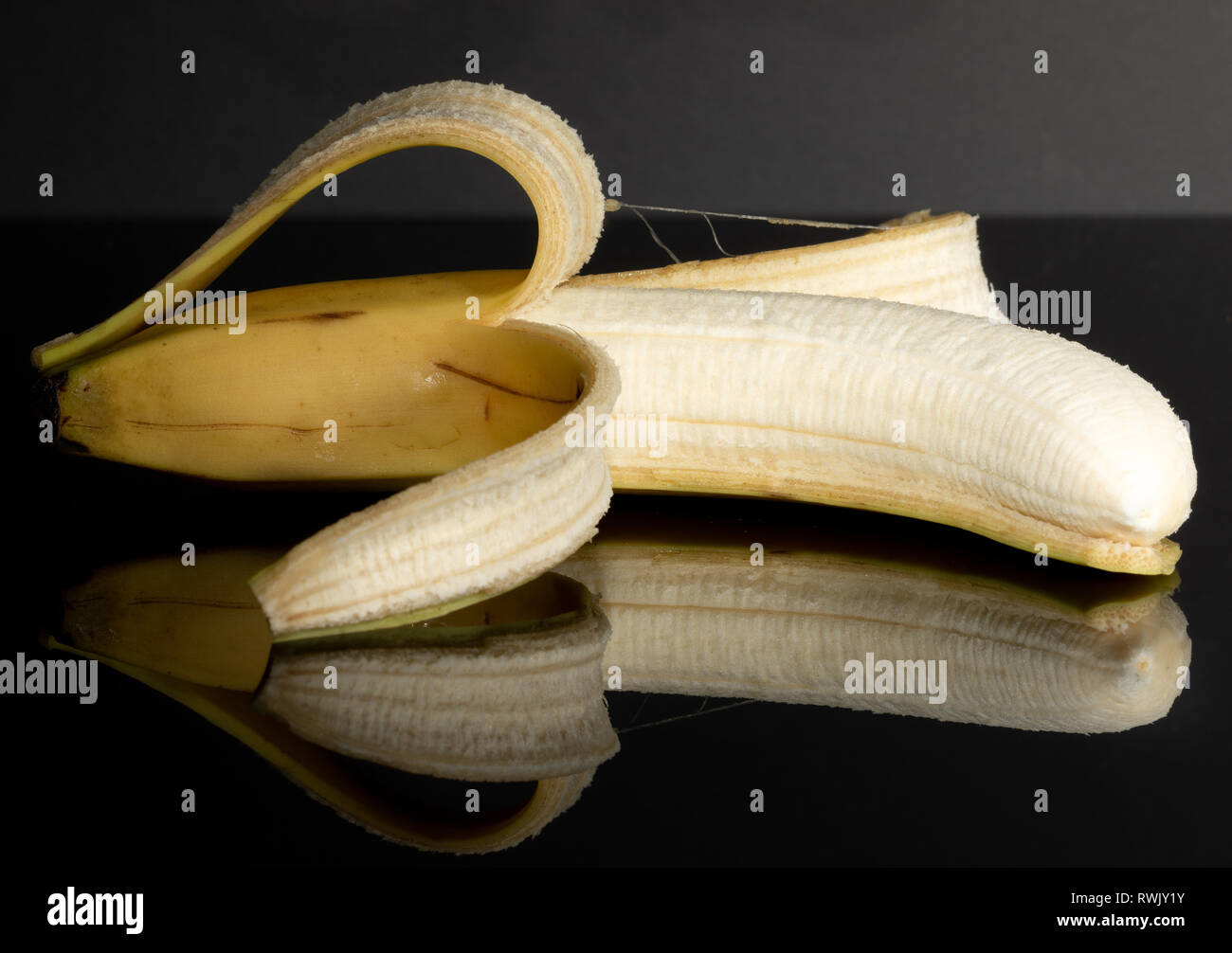 Banana on a black background with the mirror reflection. A modern ...