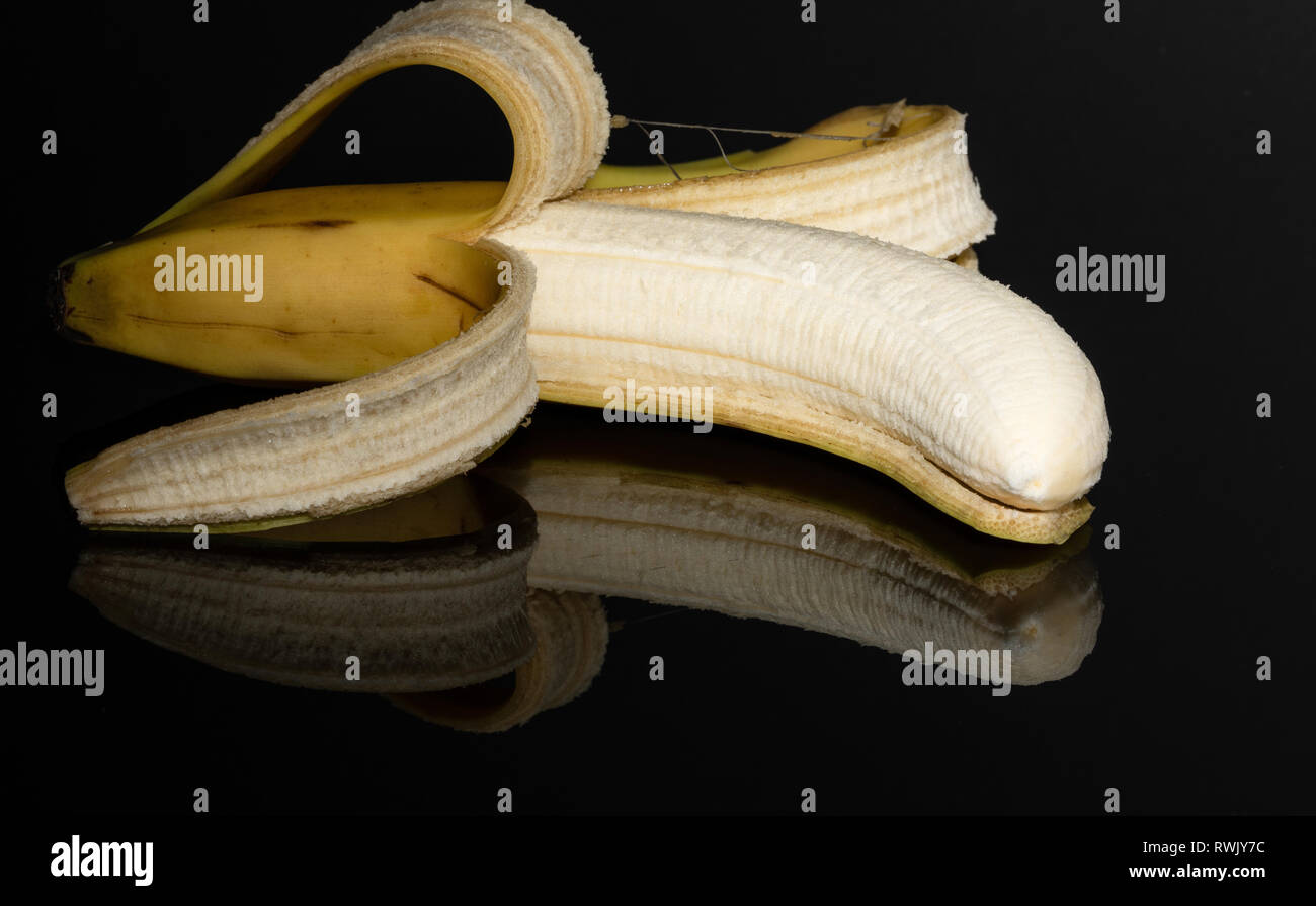 Banana on a black background with the mirror reflection. A modern ...