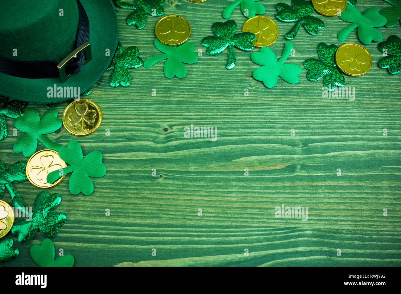 St Patricks Day frame of shamrocks, gold coins and leprechaun hat on ...