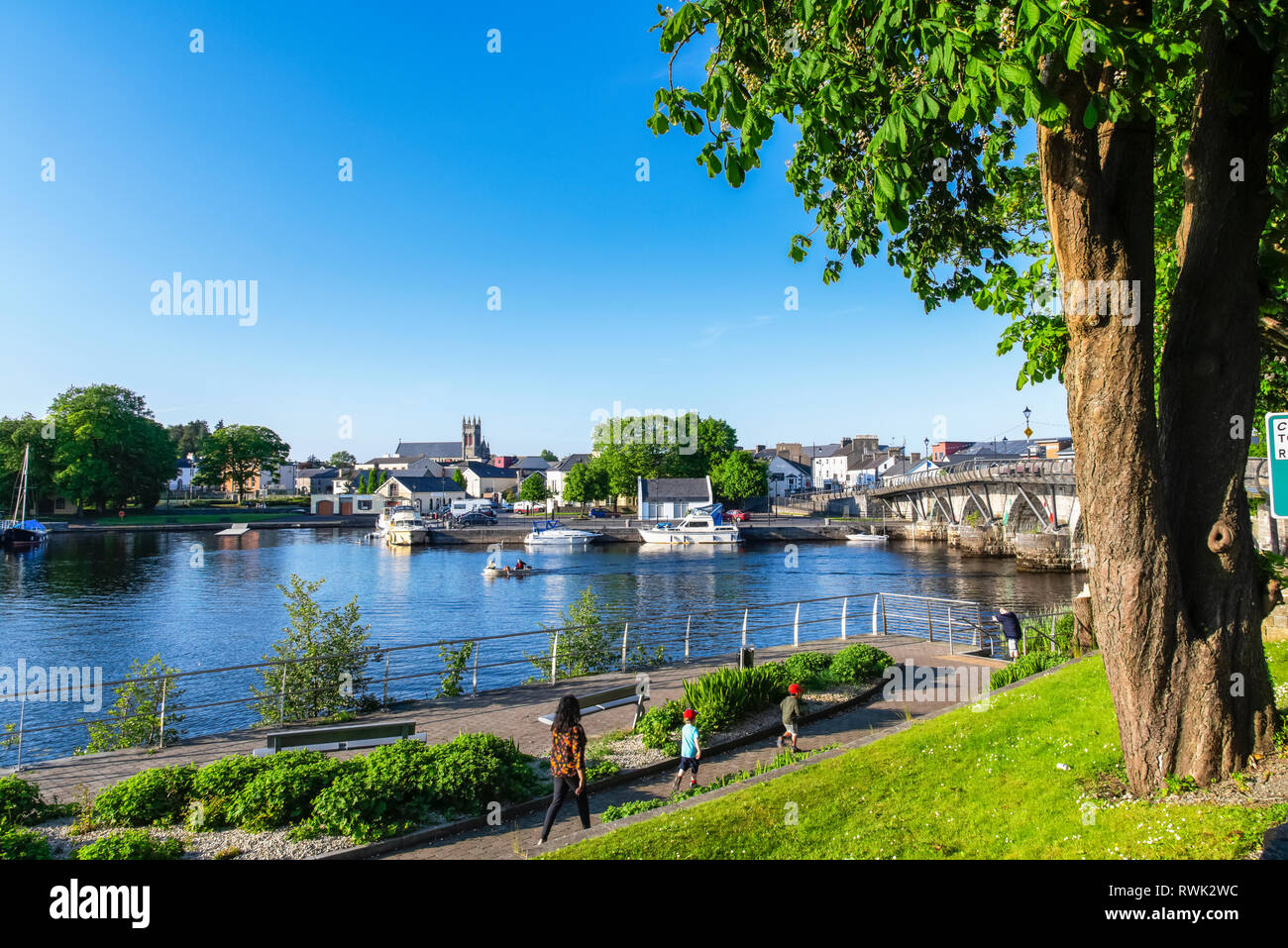 A mother and two young sons walk on the path along the River Shannon ...