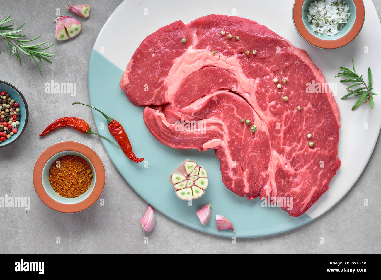 Raw steak. Meat with spices and herbs. Top view on light stone ...