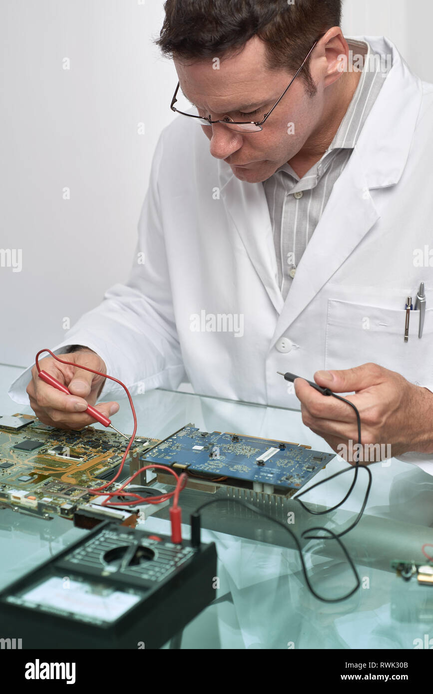 Senor male tech fixes motherboard in computer repair shop. Toned image ...