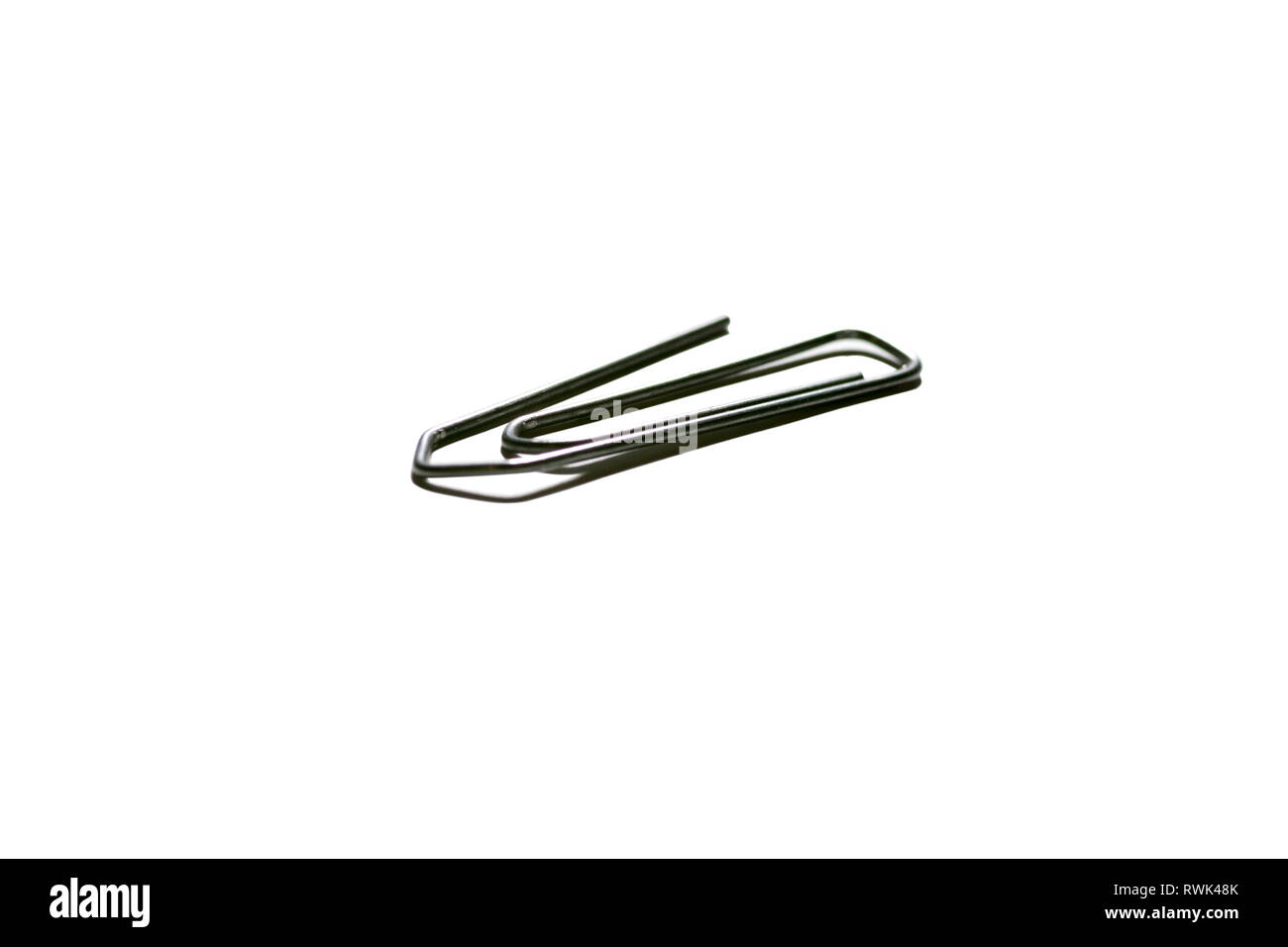 single metallic paper clip in white background Stock Photo - Alamy