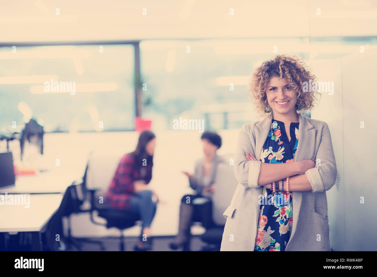Portrait of successful female software developer with a curly hairstyle ...
