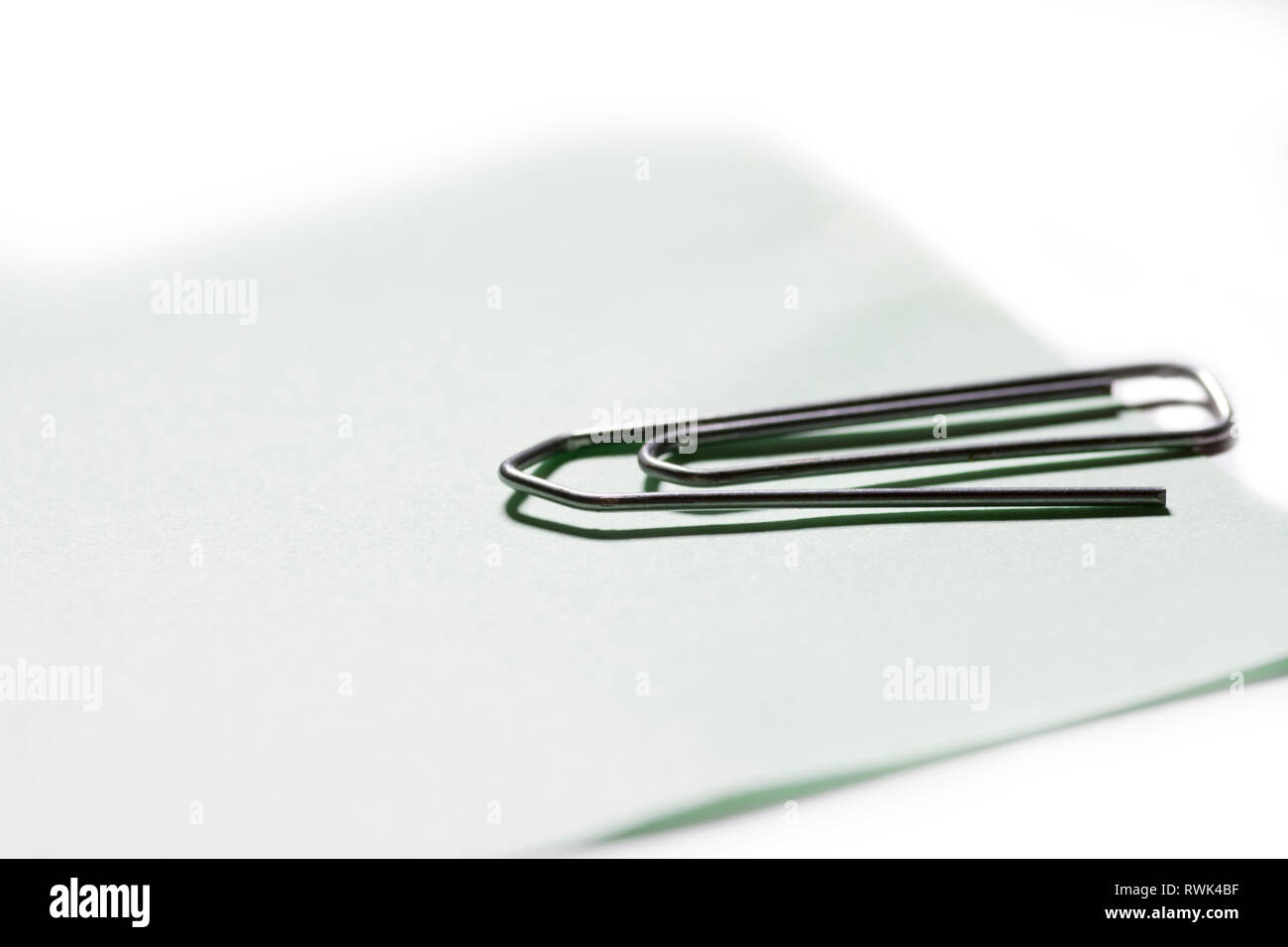 single metallic paper clip in white background Stock Photo - Alamy