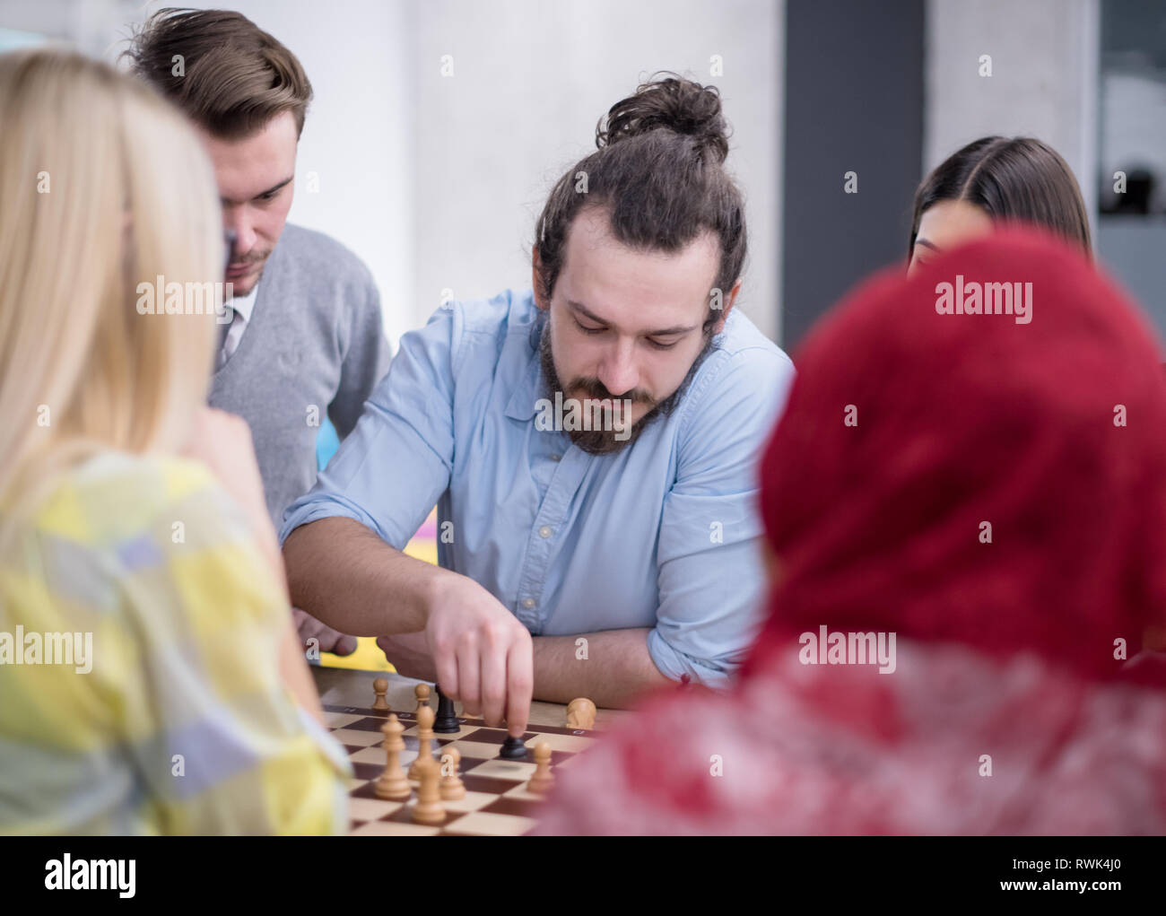 a multiethnic group of business people playing chess while having a ...