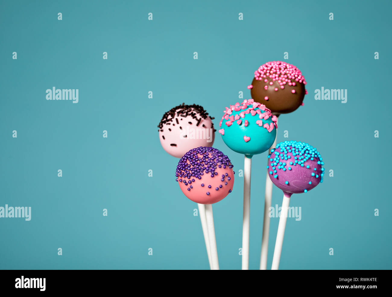 Colorful cake pops with sprinkles over a teal blue background Stock ...