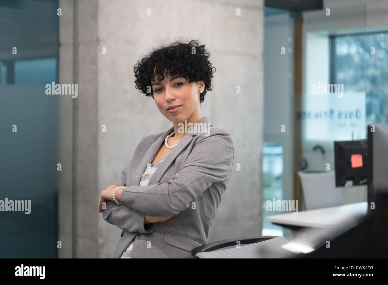 Portrait of successful female software developer with a curly hairstyle ...