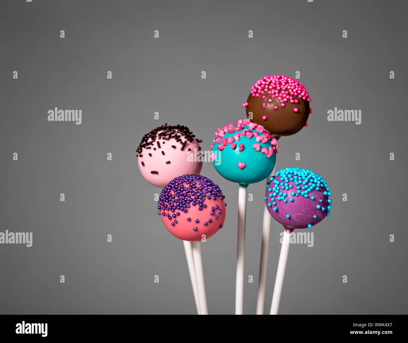 Colorful cake pops with sprinkles over a grey background Stock Photo ...