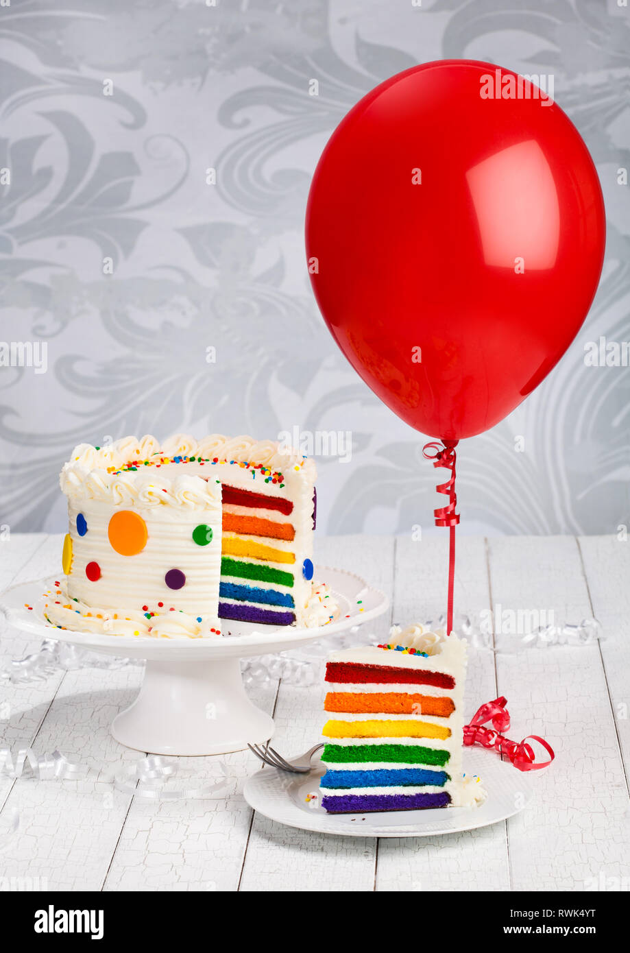 Rainbow birthday Cake with red balloon Stock Photo - Alamy