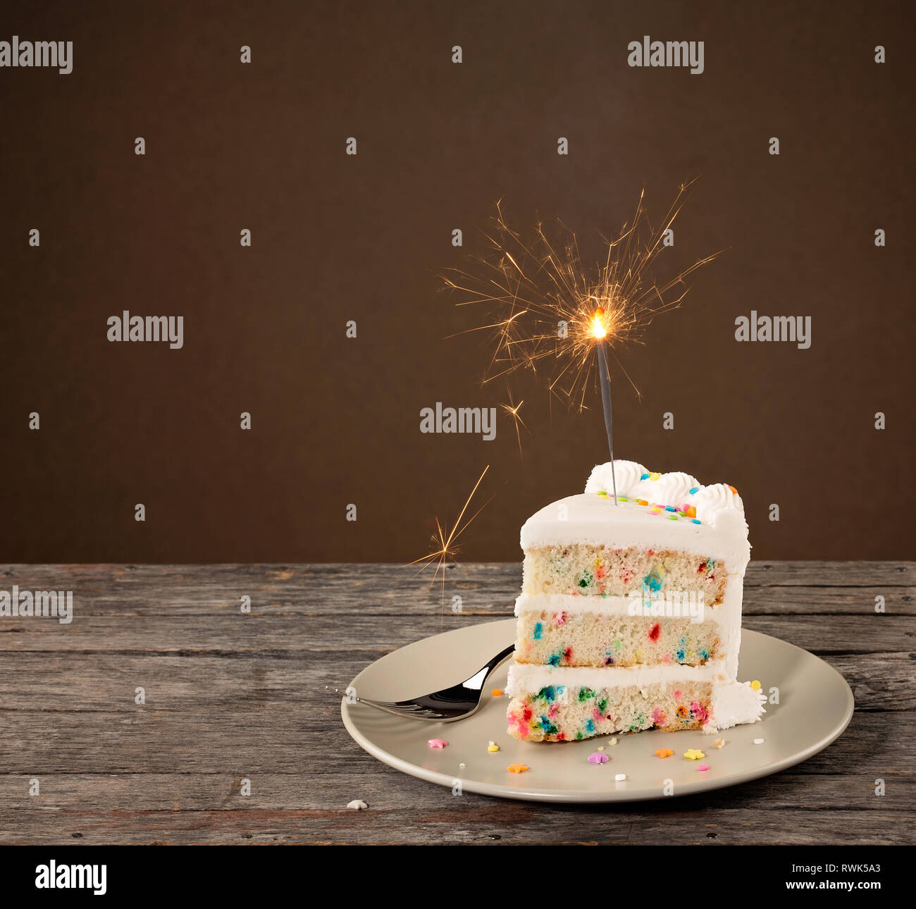 Slice of Birthday Cake with colorful sprinkles and lit sparkler Stock ...