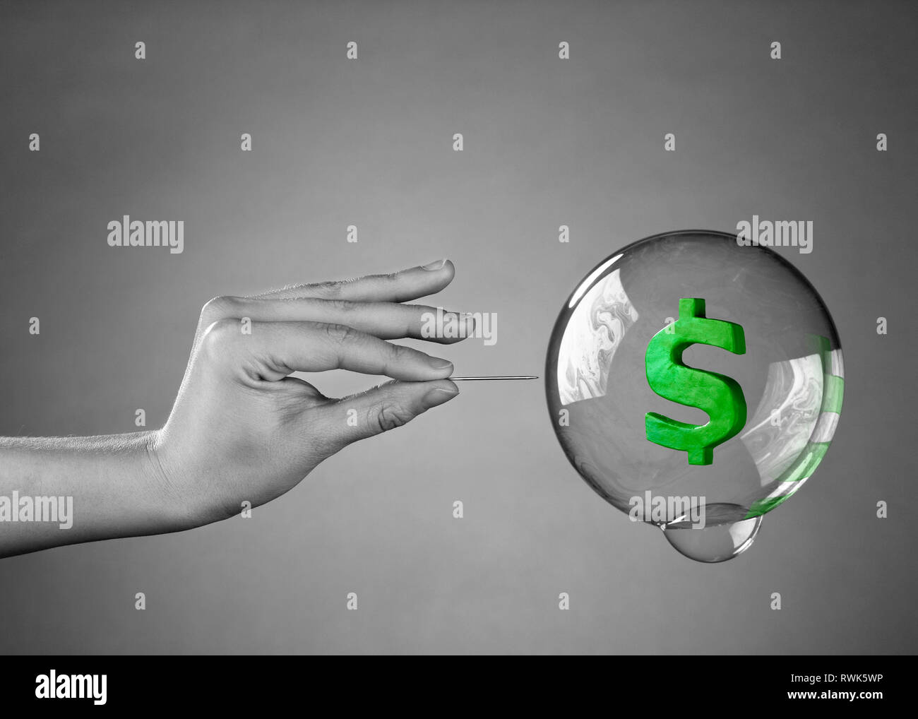 A hand about to burst a money bubble with a pin. Metaphor for an ...