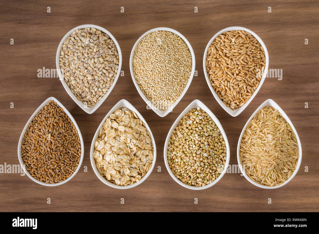 An assortment of whole grains in bowls over a wooden background Stock ...