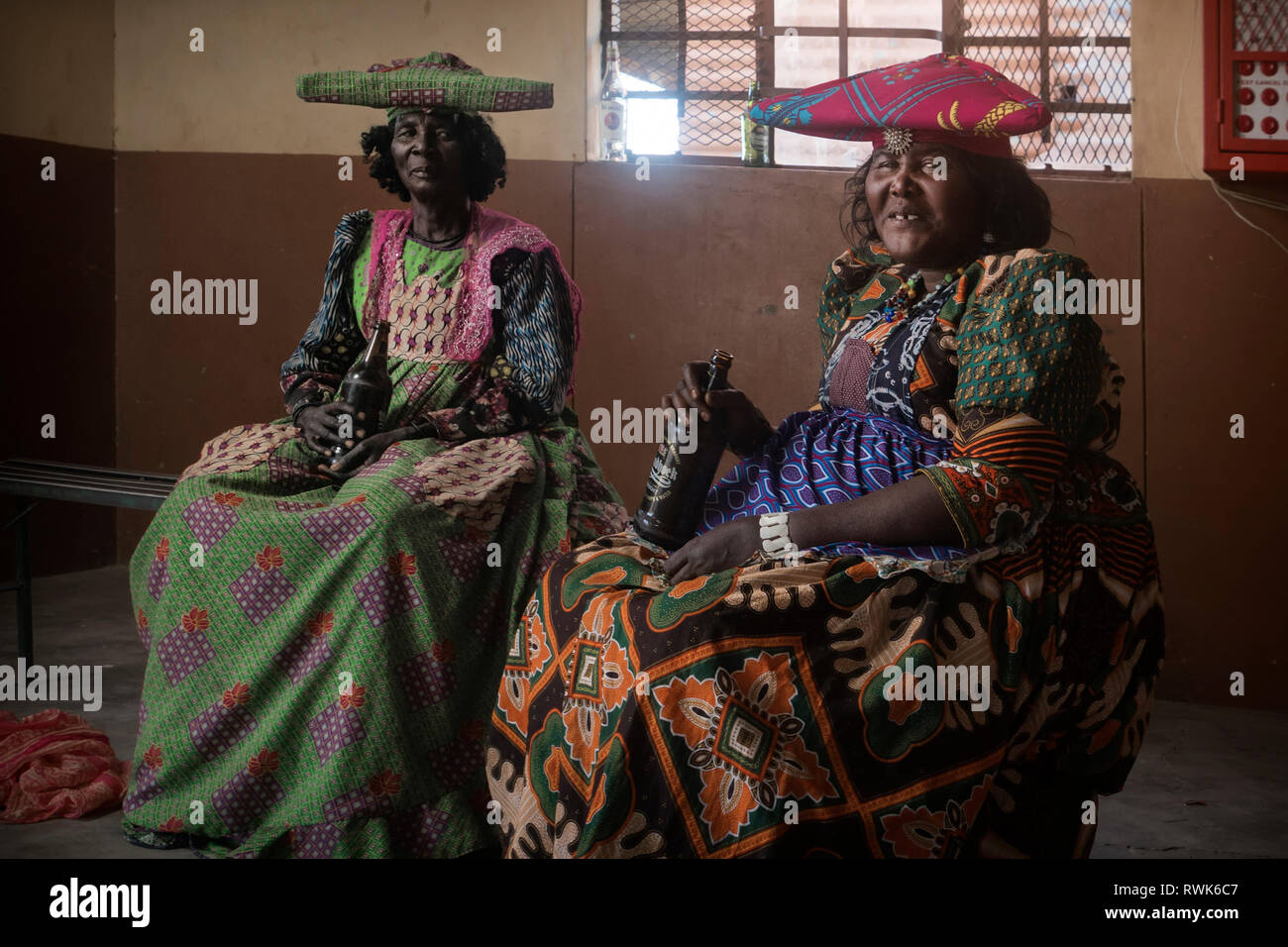 Herero women drink beer inside a store in Purros, Namibia Stock Photo ...
