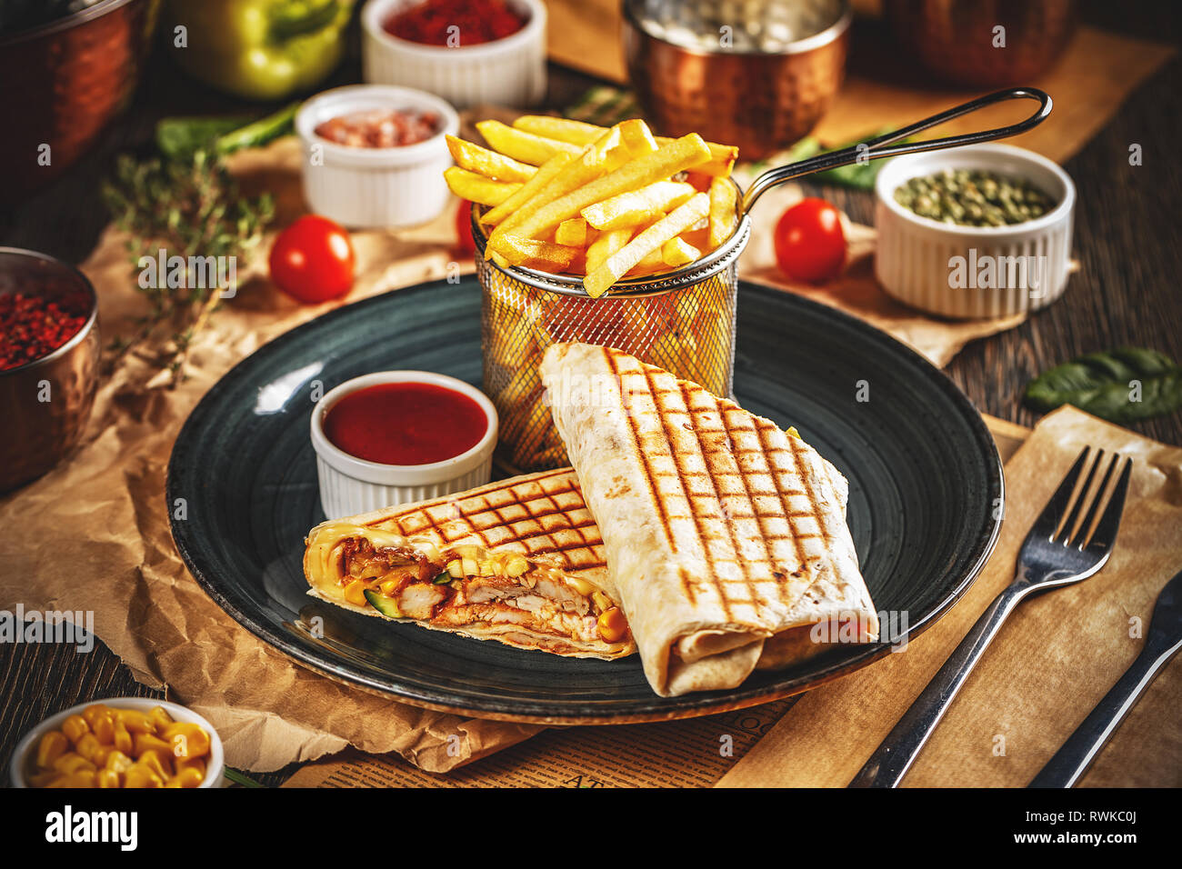 Wrap with grilled chicken served with chili sauce and french fries ...