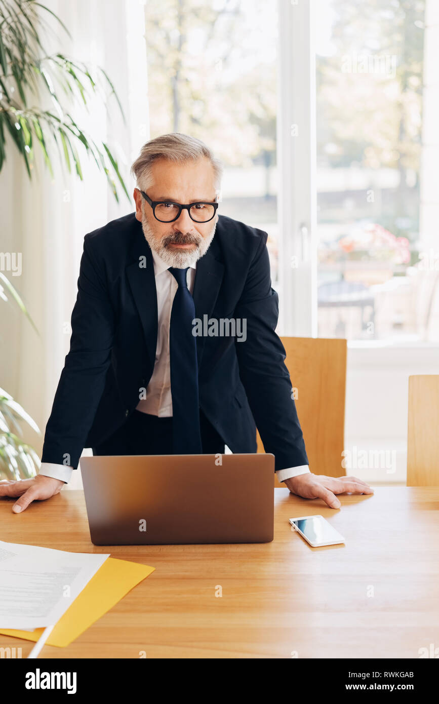 Business a man standing over a desk hi-res stock photography and images ...