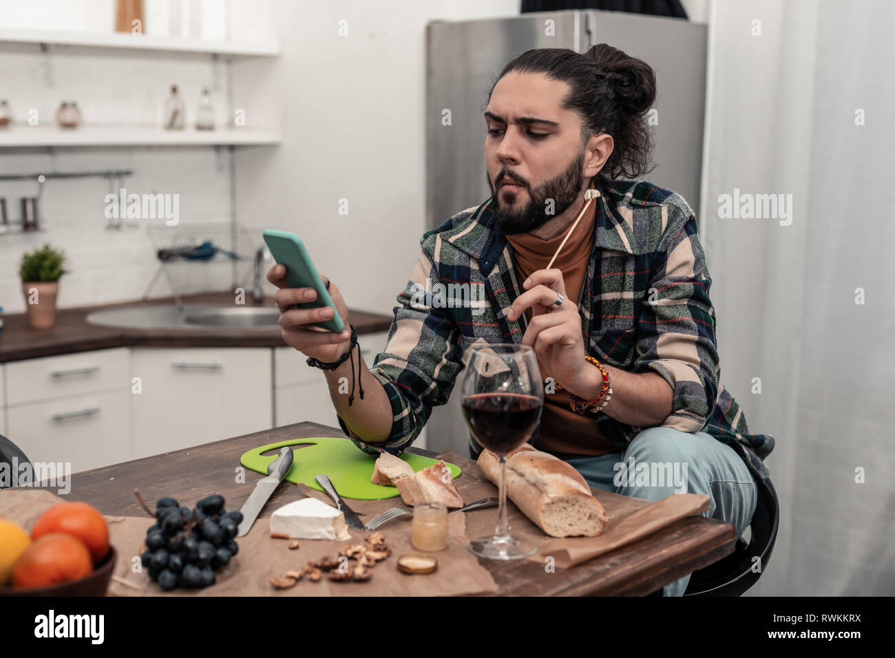 Nice thoughtful young man browsing the Internet Stock Photo - Alamy
