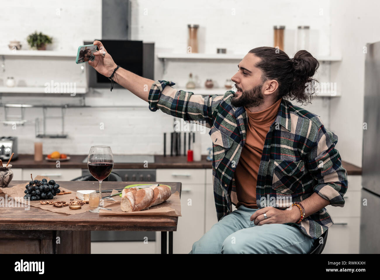 Joyful brunette man looking into the smartphone camera Stock Photo - Alamy