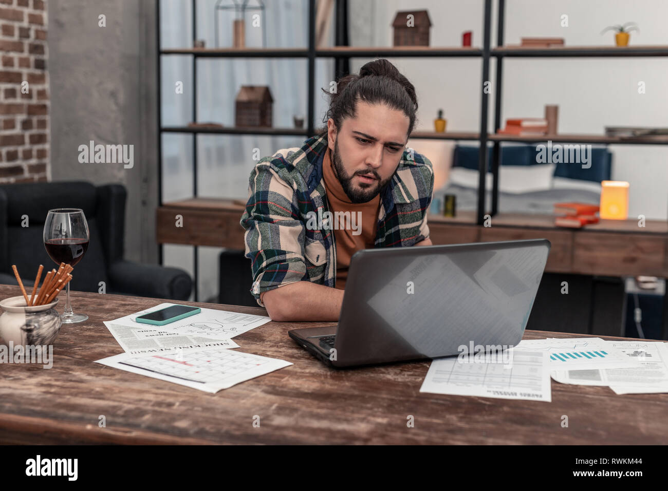 Serious young man looking at the computer screen Stock Photo - Alamy