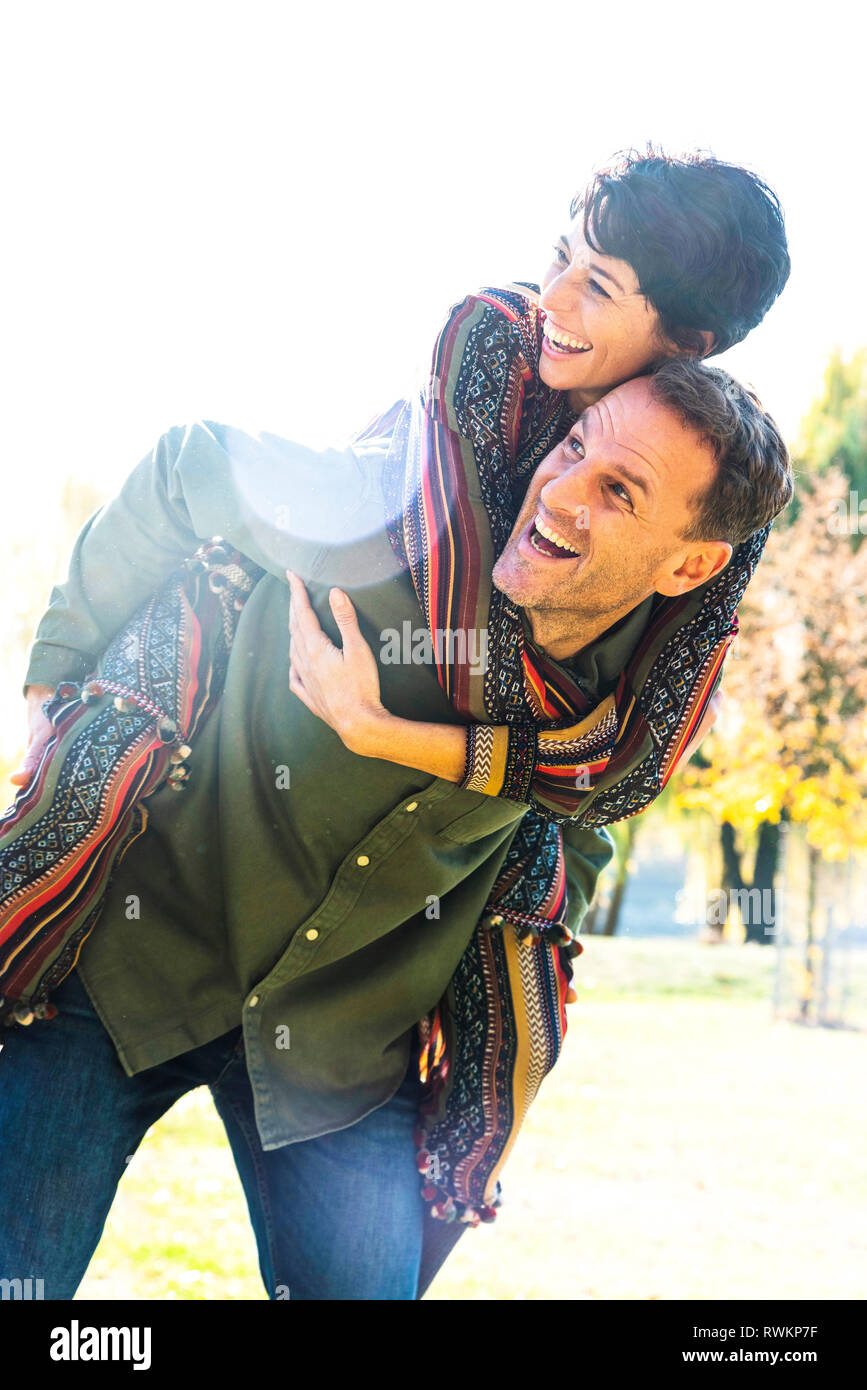Couple playing piggyback in park Stock Photo - Alamy