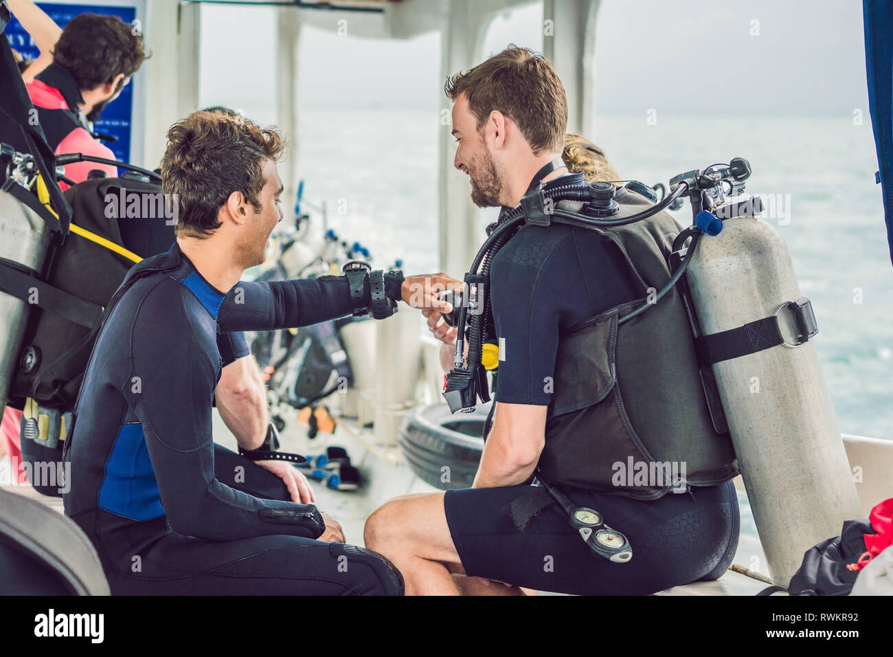 Diving instructor helps a beginner diver prepare for diving Stock Photo ...