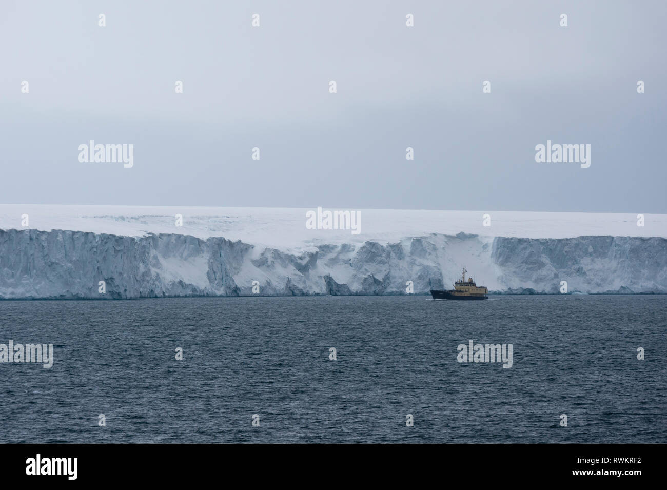 Ship passing ice cliffs of polar ice cap, Austfonna Nordaustlandet ...