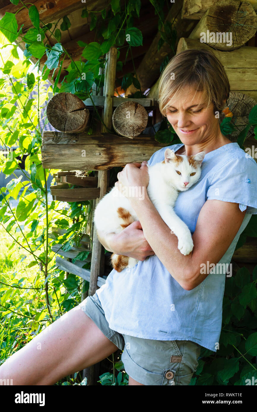 Woman carrying cat in countryside Stock Photo - Alamy