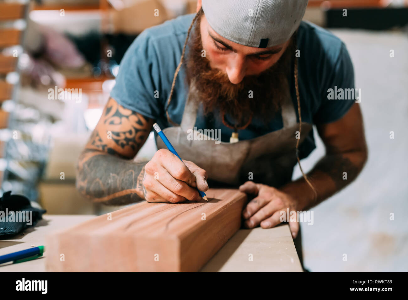 Axe maker measuring wood for axe handle in workshop Stock Photo - Alamy
