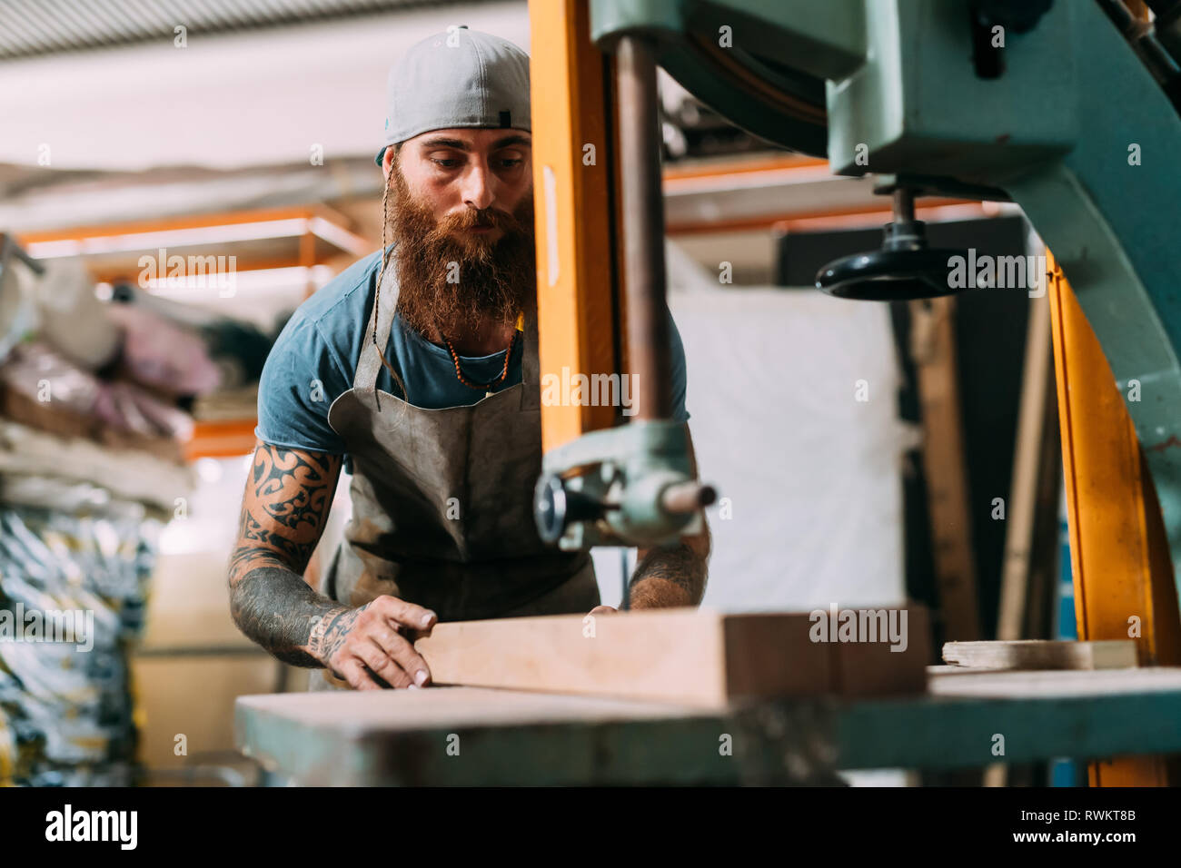 Axe maker cutting wood for axe handle in workshop Stock Photo - Alamy