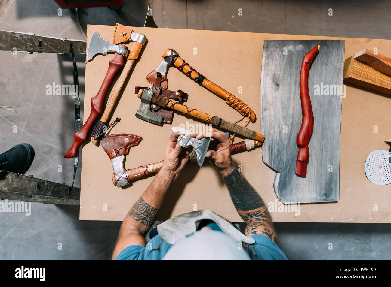Axe maker with variety of axes on workbench Stock Photo - Alamy