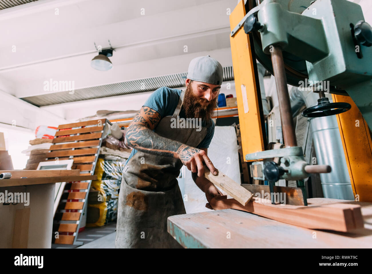 Axe maker cutting wood for axe handle in workshop Stock Photo - Alamy
