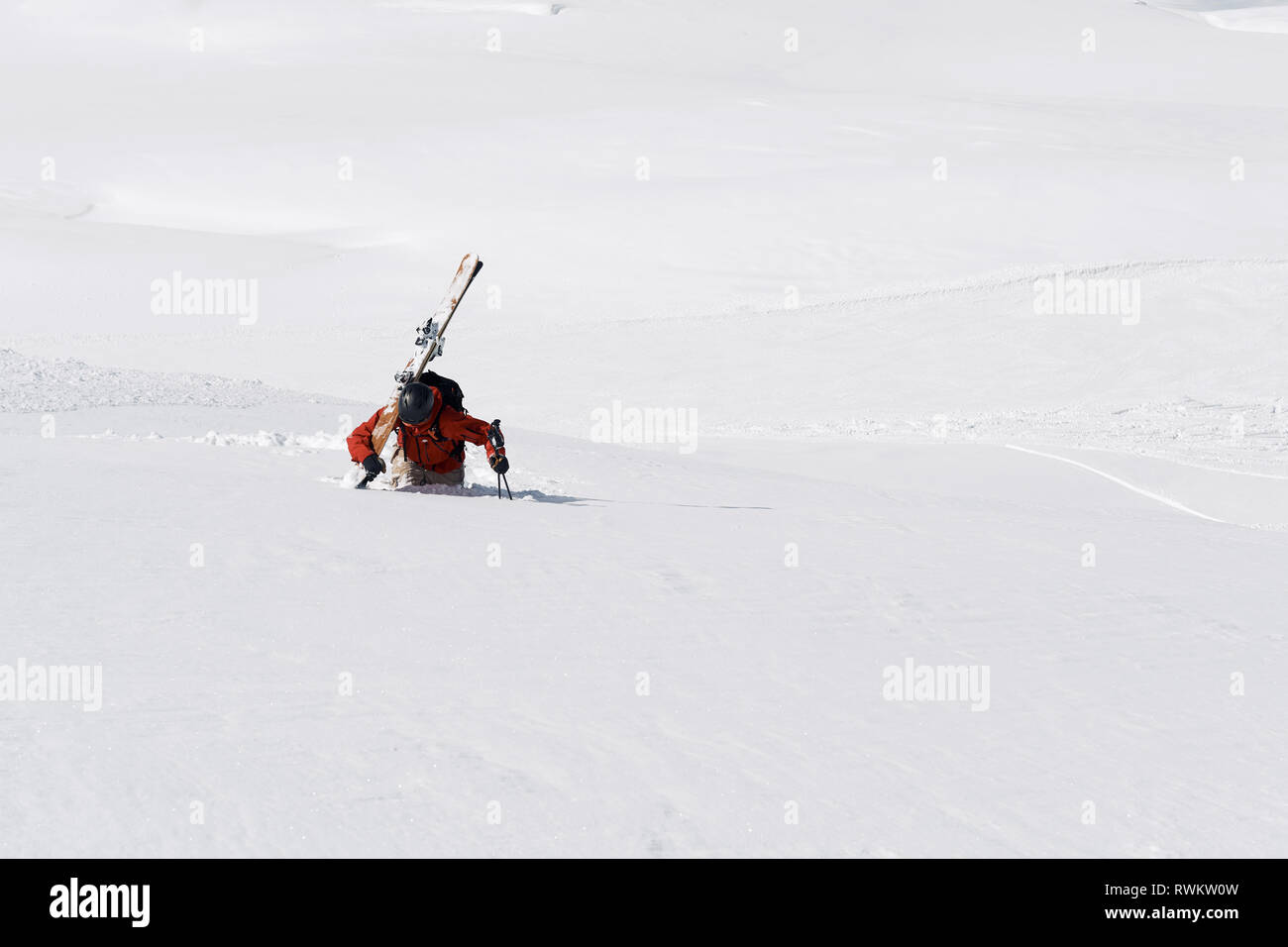 Male skier trudging up mountain through deep snow, Alpe-d'Huez, Rhone ...