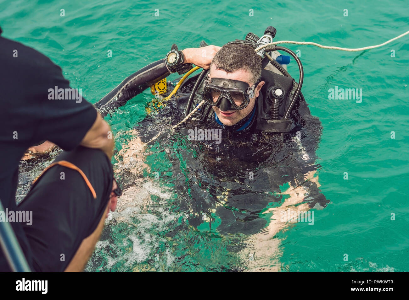 Happy diver returns to the ship after diving Stock Photo - Alamy