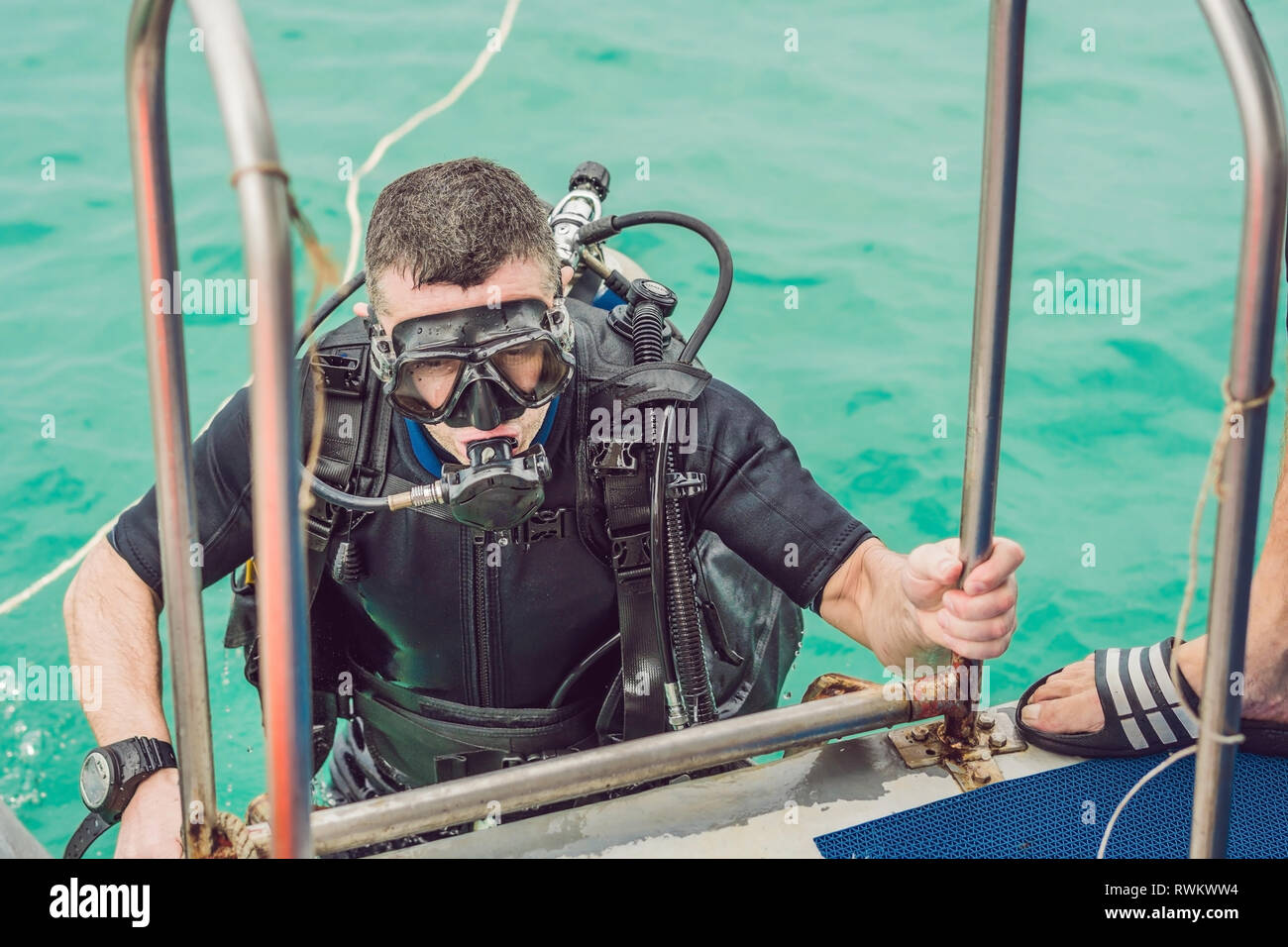 Happy diver returns to the ship after diving Stock Photo - Alamy