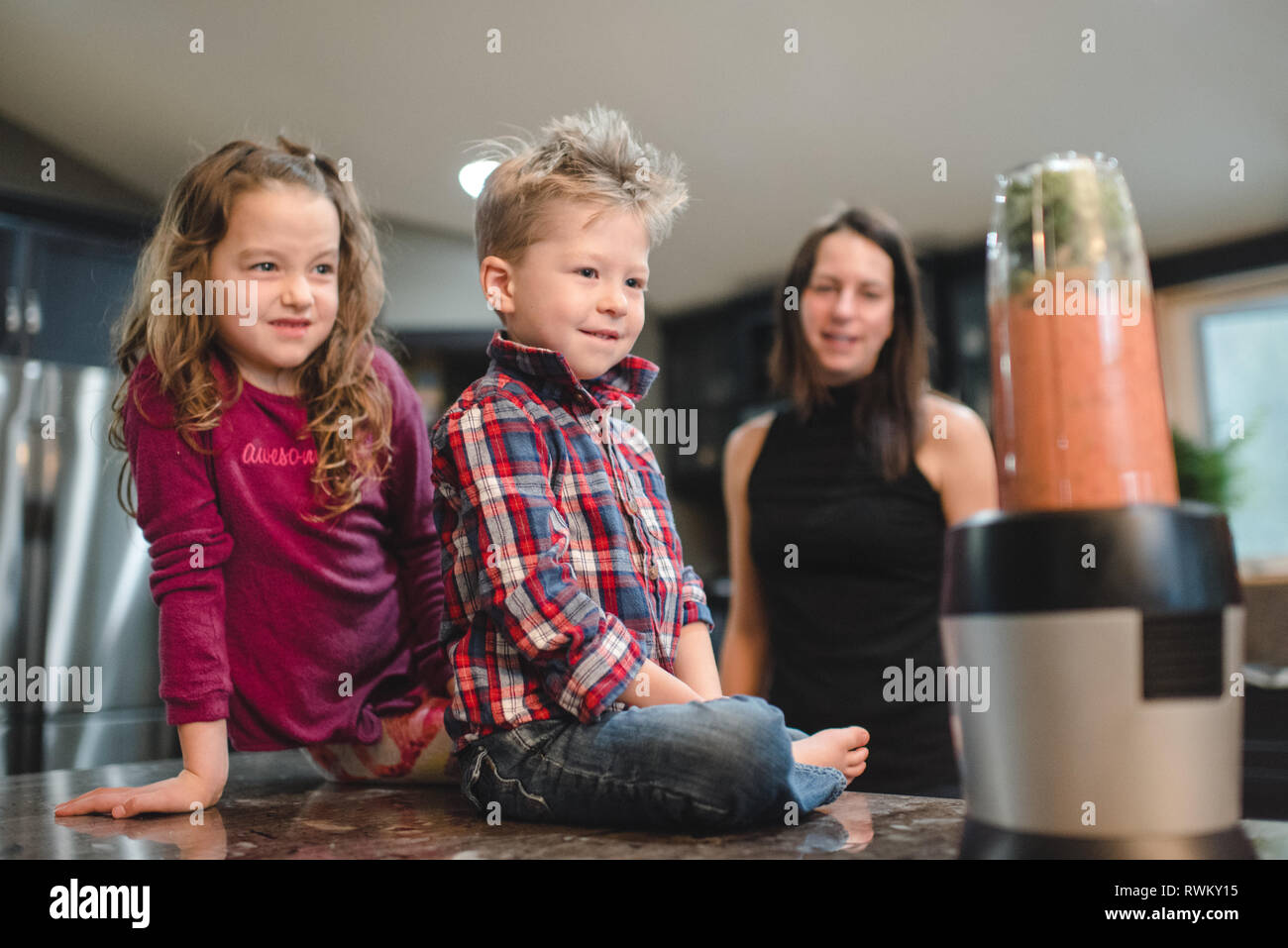 Mother and children watching blender making smoothie Stock Photo - Alamy