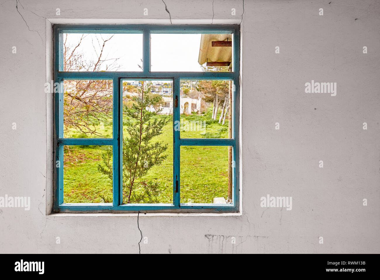 Interior of a ruined house with old, dirty and cracked white wall and a ...