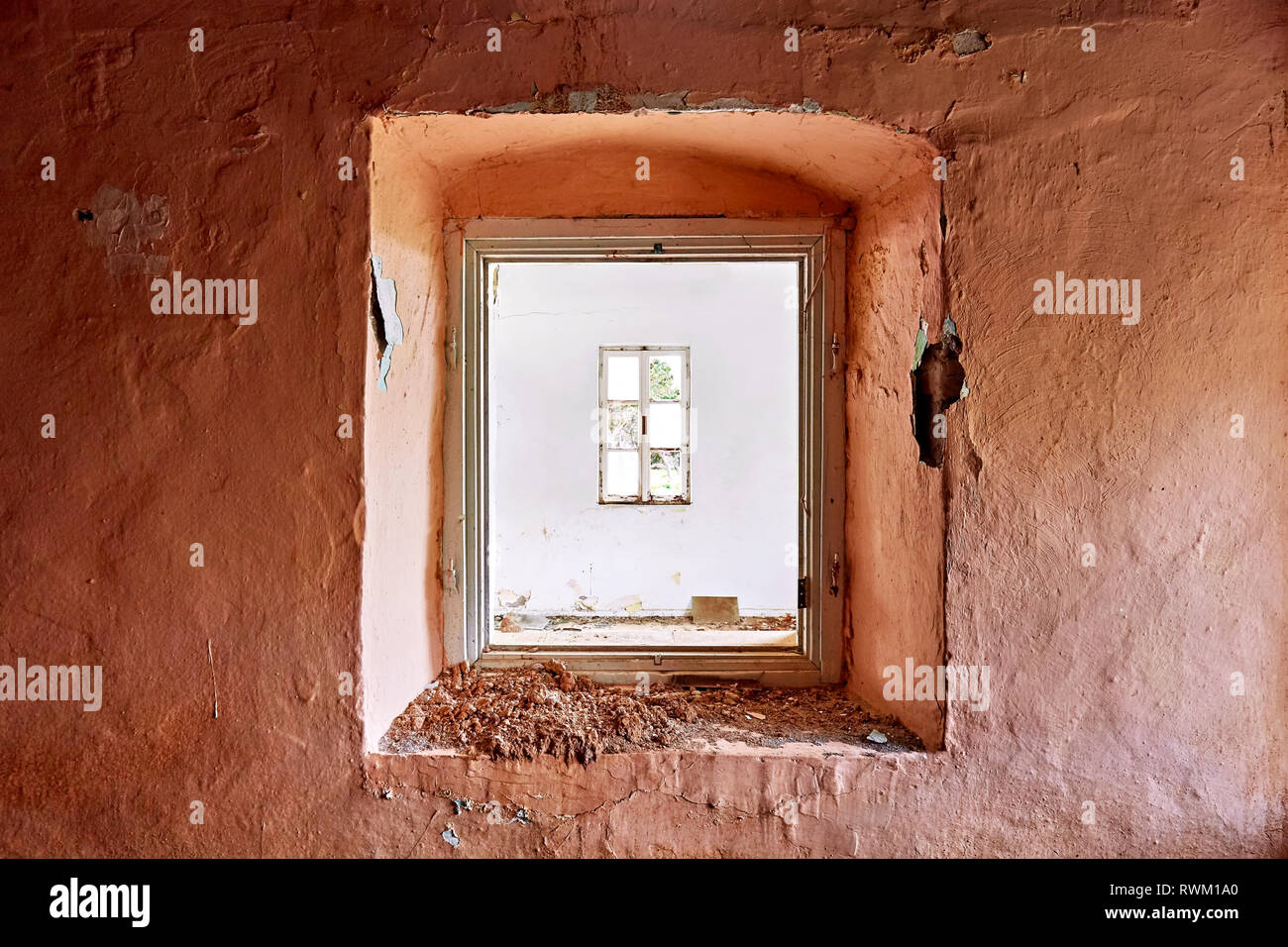 Old window frame with broken glass is framed by another window frame in ...