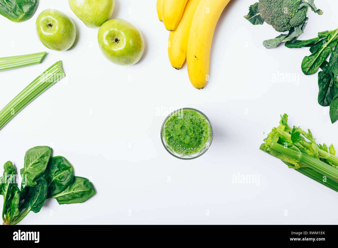 View from above glass of green smoothie among fruits and vegetables ...