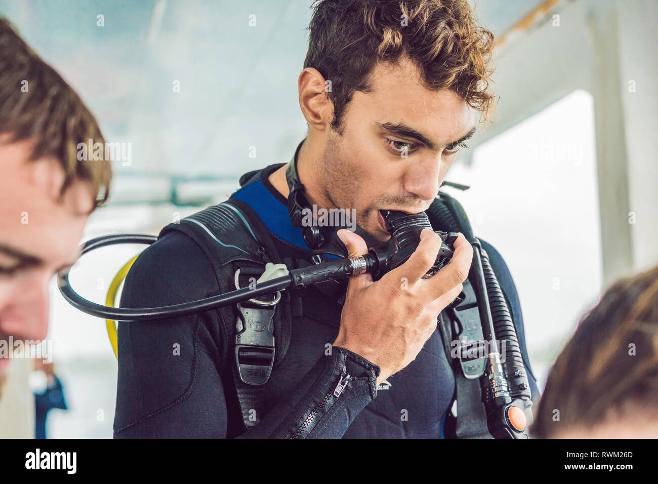 Diving instructor helps a beginner diver prepare for diving Stock Photo ...