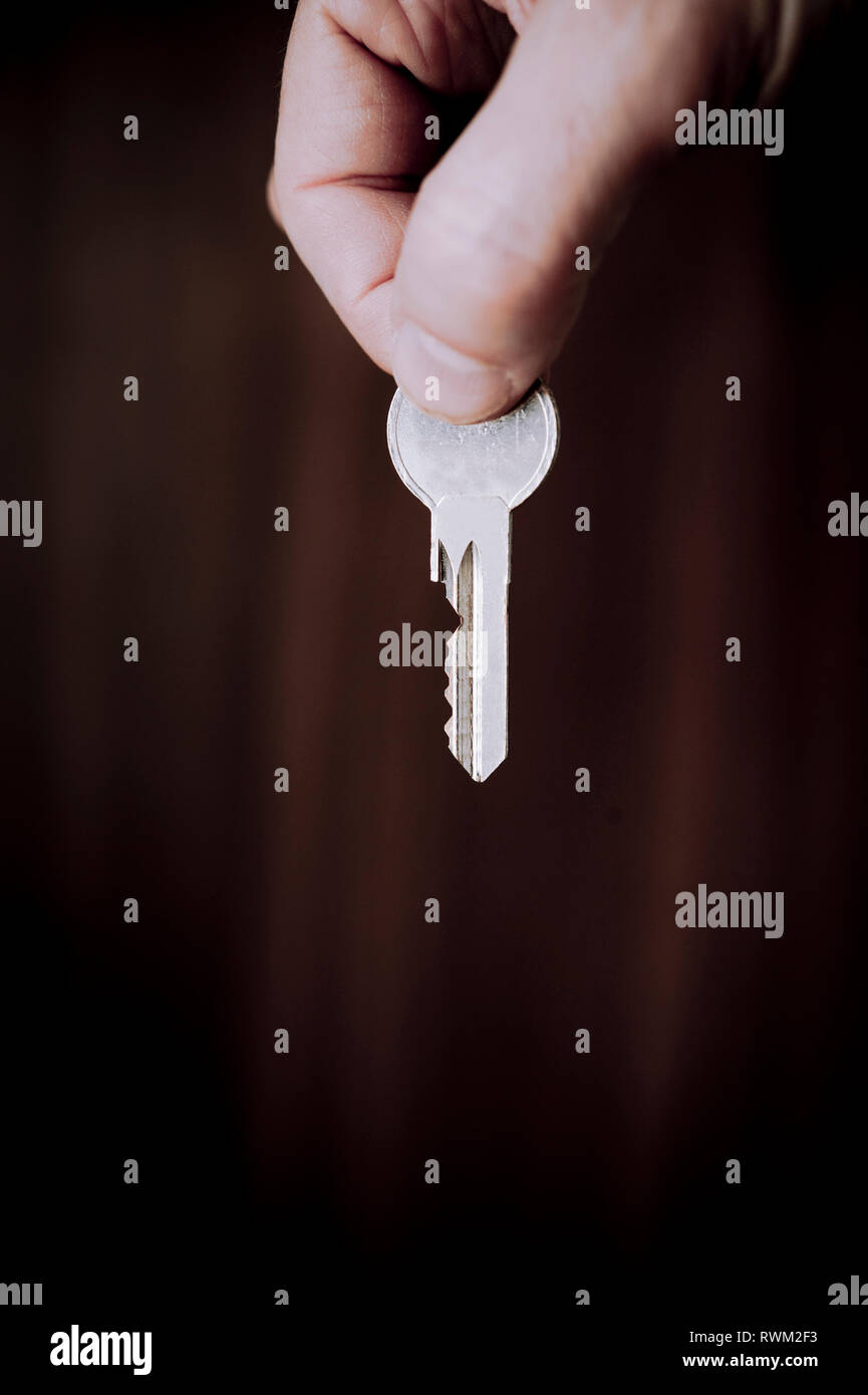 hand holding a cut key - image for book cover Stock Photo - Alamy