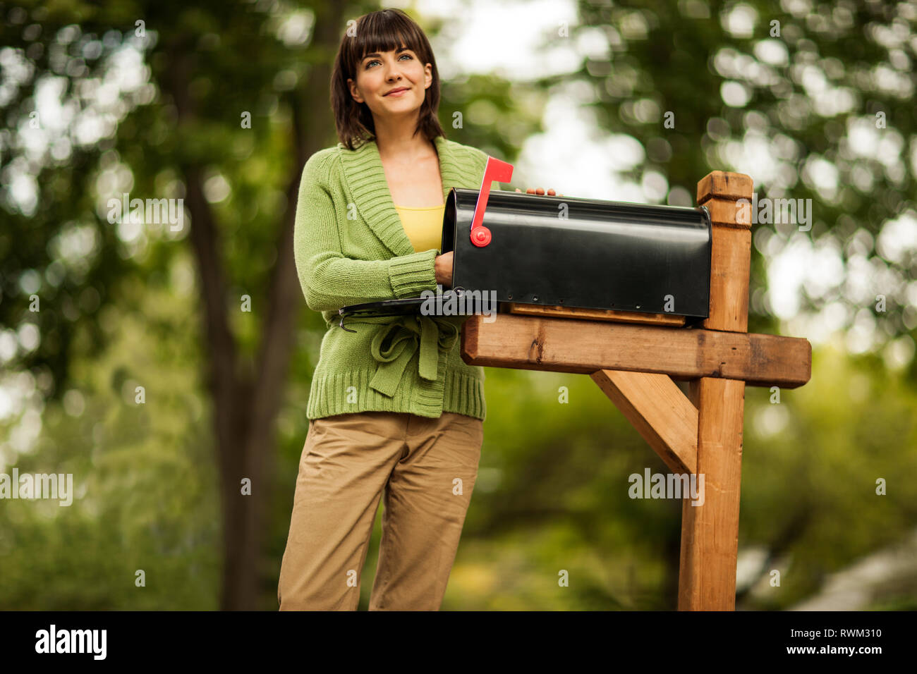 Mid adult woman checking mail box Stock Photo - Alamy