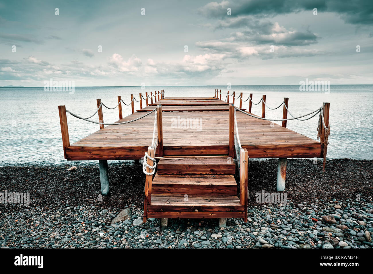 Rustic wooden pier on the sea on a moody and cloudy winter day Stock ...